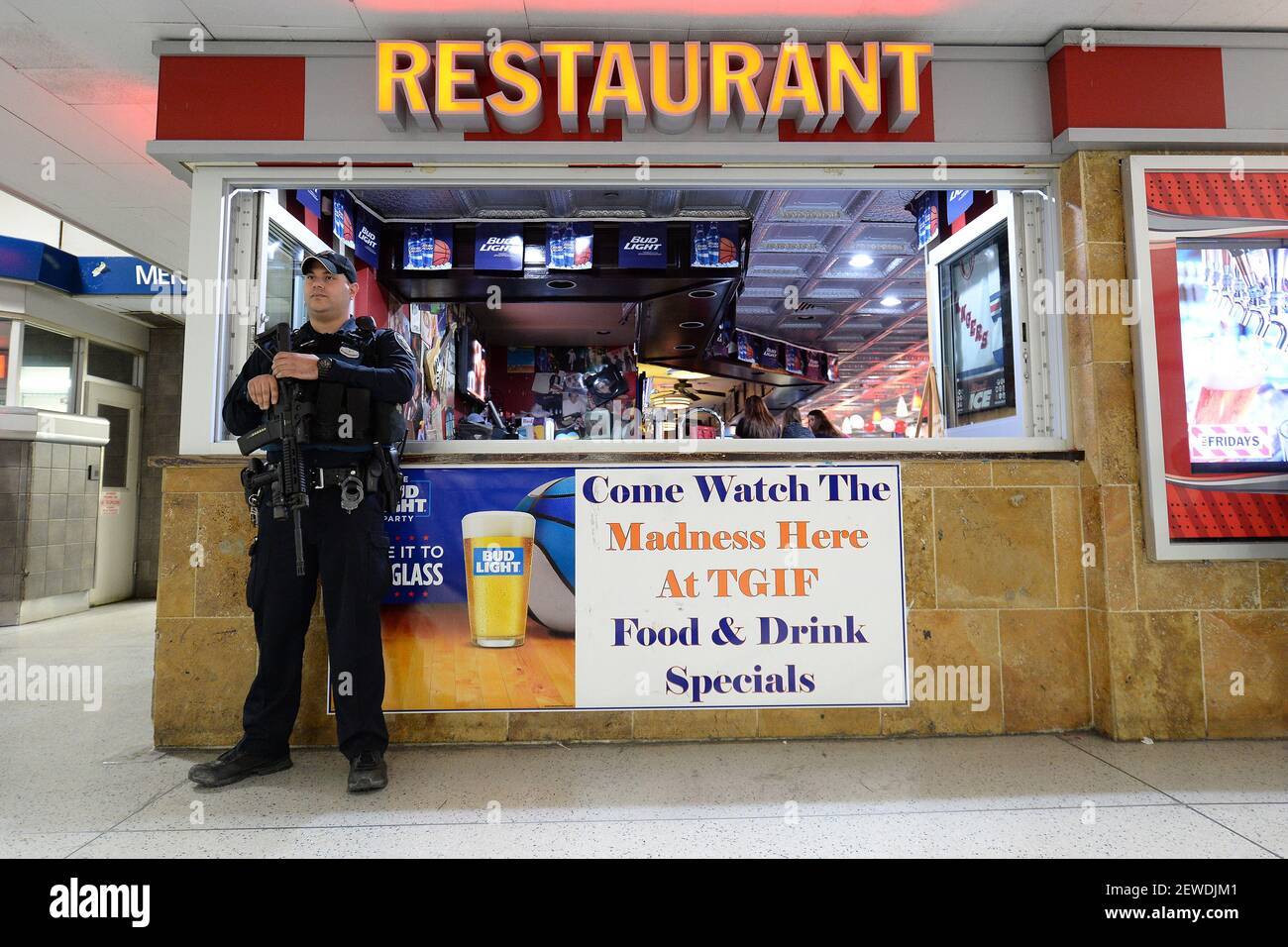 An Amtrak Police officer wears a machine as he stands guard inside New ...