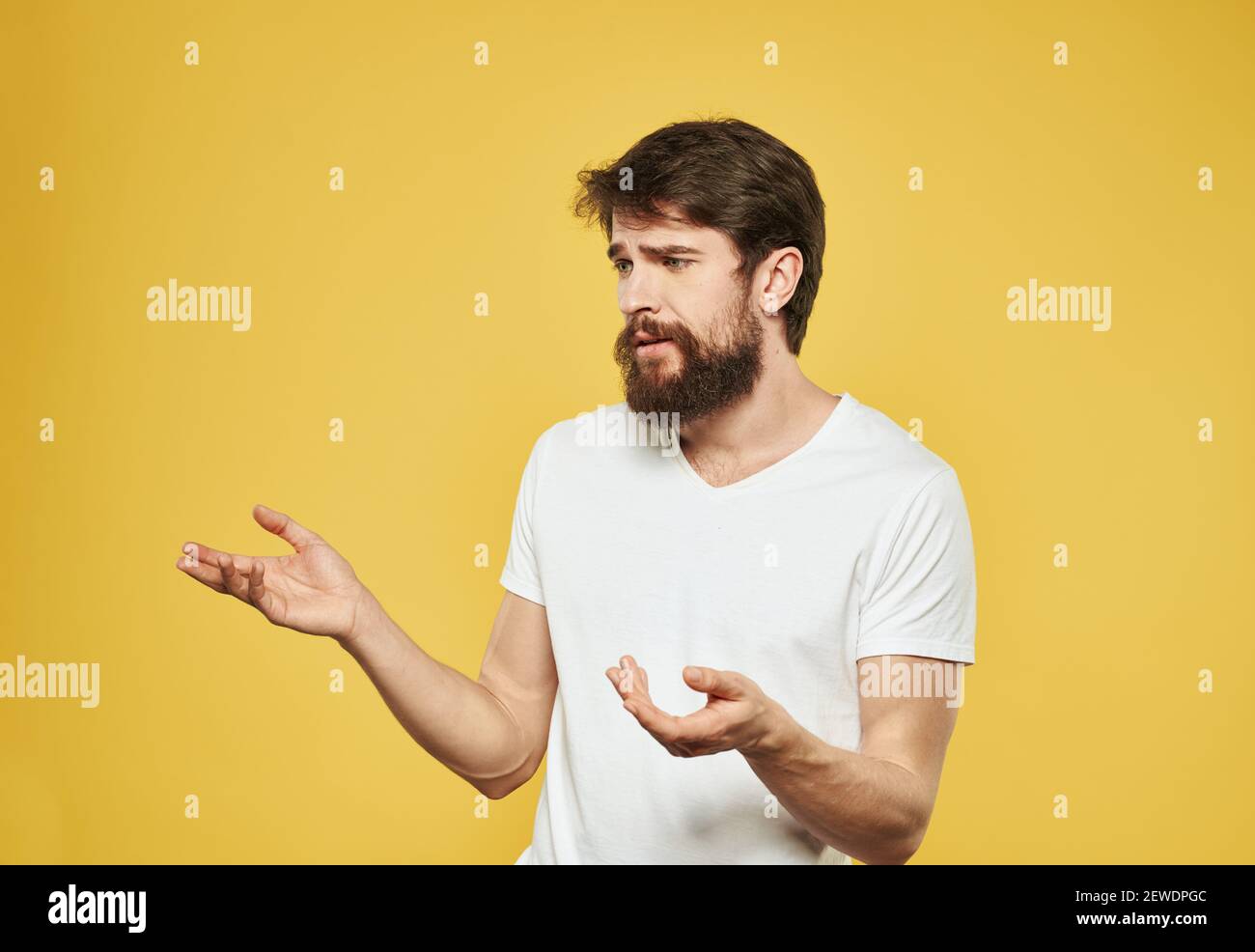 Emotional guy gesturing with his hands on a yellow background model ...
