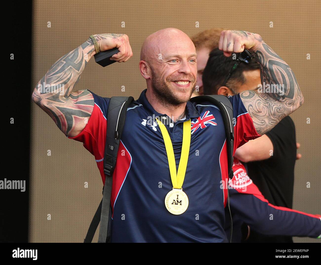 UK athlete Michael Yule flexes his muscles during closing ceremonies ...