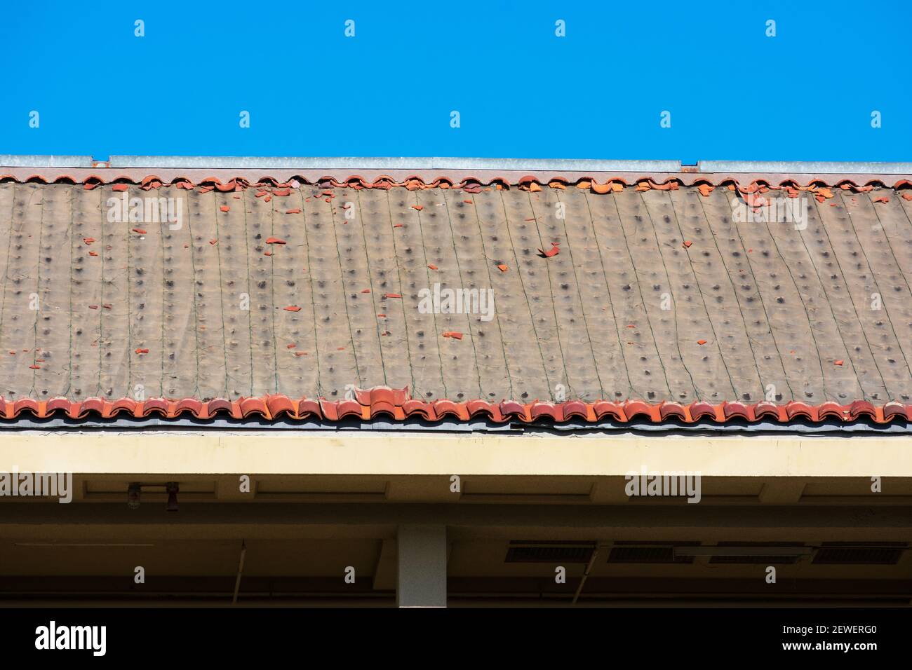 Side view of a pitched roof with removed clay roof tiles during office ...
