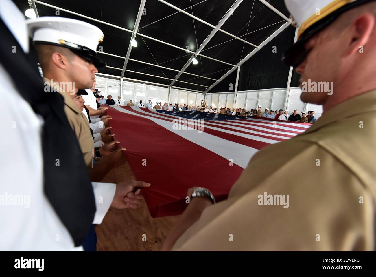 Members of the armed services furl a 50-foot U.S. Flag marking the end ...