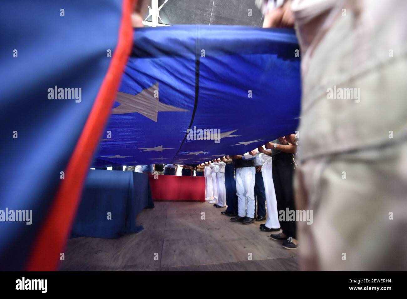 Members of the armed services furl a 50-foot U.S. Flag marking the end ...