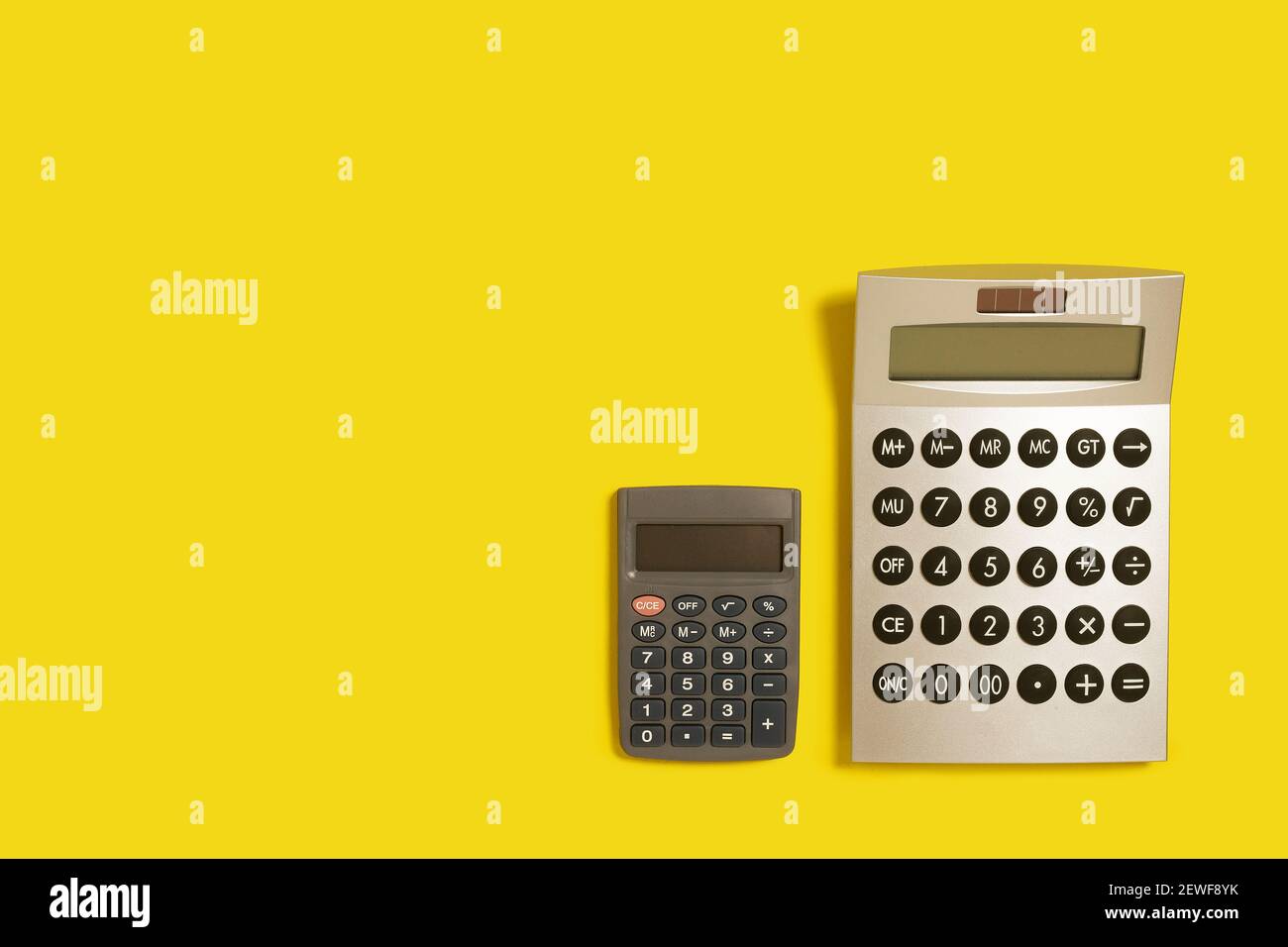 two calculators on a yellow background Stock Photo - Alamy