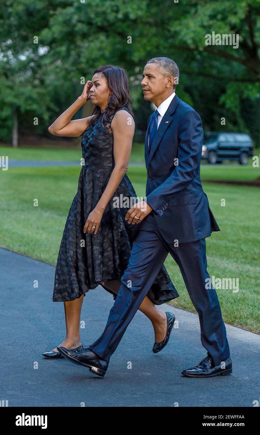 U.S. President Barack Obama and first lady Michelle Obama walk across ...