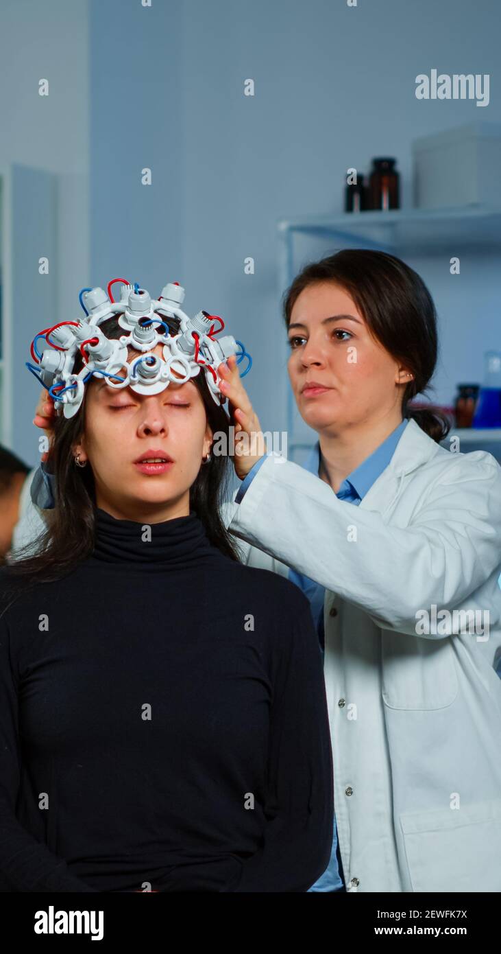 Asistance of neurological doctor putting eeg headset on patient head ...