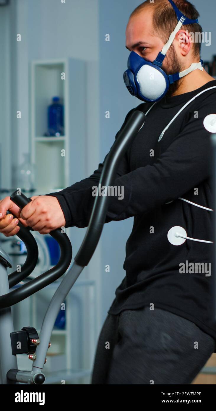 Monitor showing EKG reading of athlete running on cross trainer, while ...