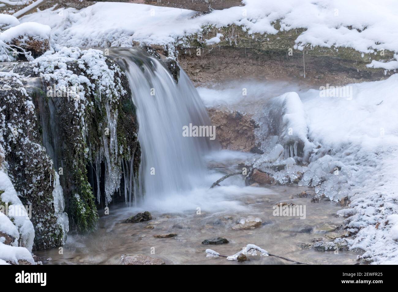 winter landscape with a small waterfall and flooded water, frozen ...