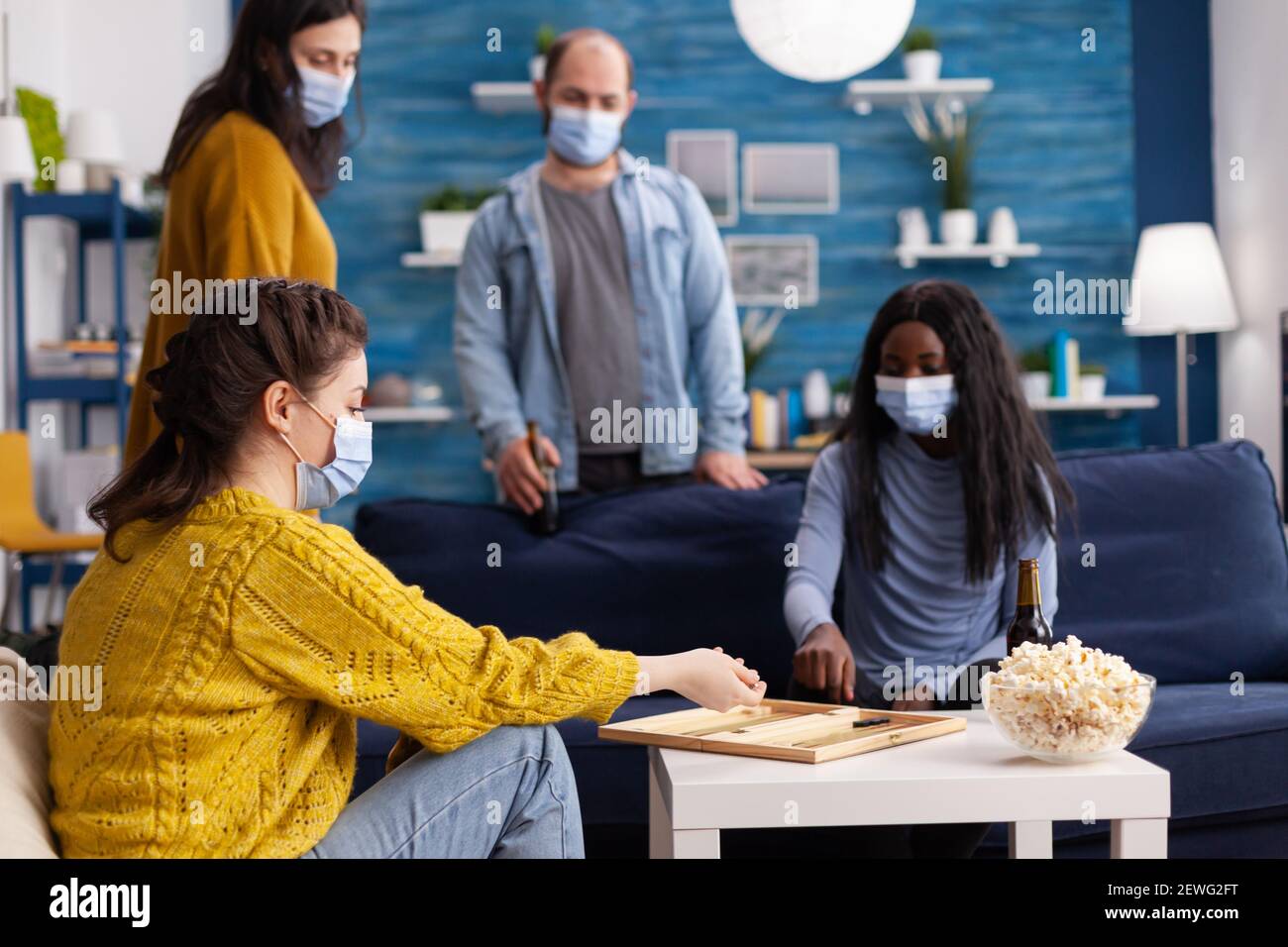 Group of cheerful multiethnic friends playing board games backgammon ...