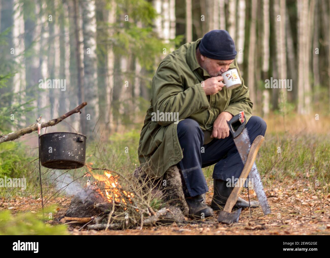 a forester in the forest drinks tea at rest, blurred forest background ...