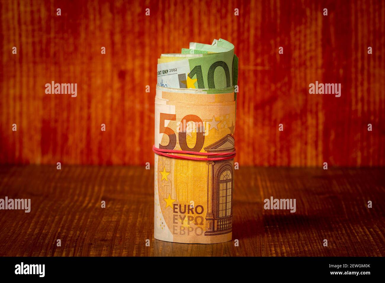 Roll of euro currency banknotes with a rubber band Stock Photo - Alamy