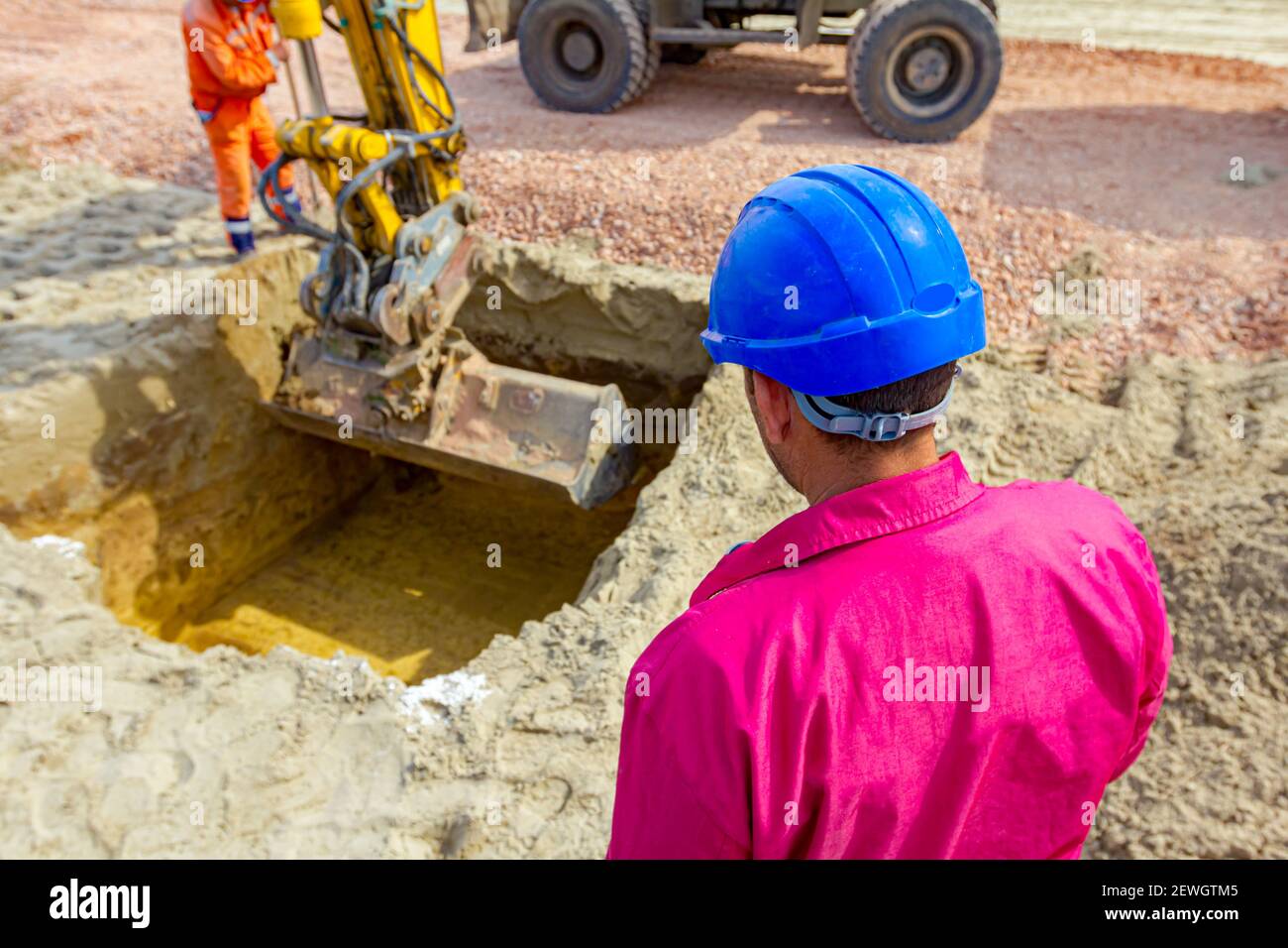 View from behind on construction worker, foreman, with safety blue ...