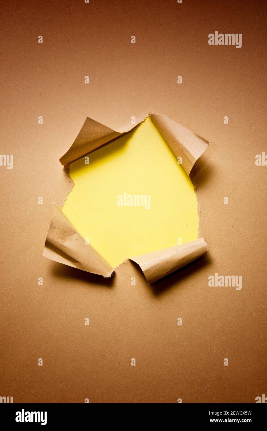 teared brown paper with yellow paper under it Stock Photo - Alamy