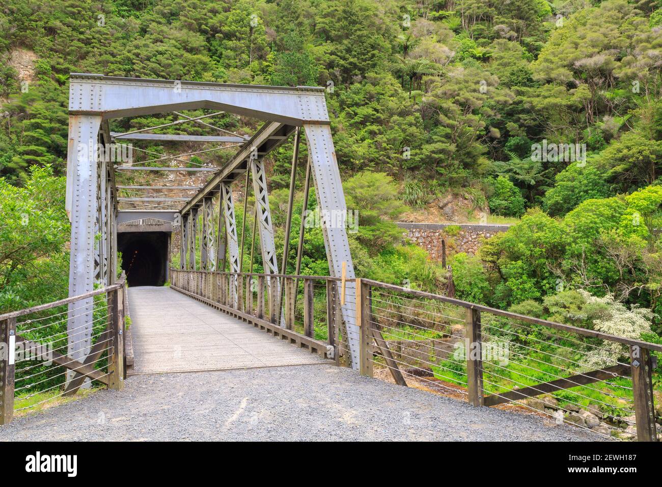 An old metal rail bridge leading to a tunnel in a cliff in the ...