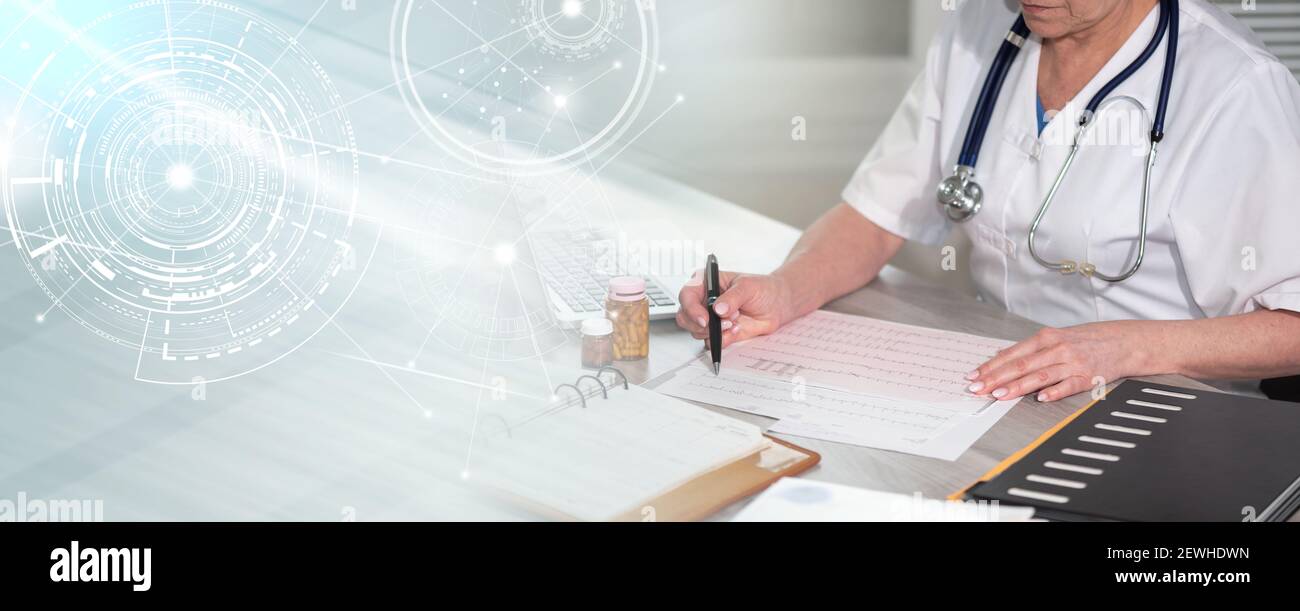 Female cardiologist examining an ecg graph in medical office; panoramic ...