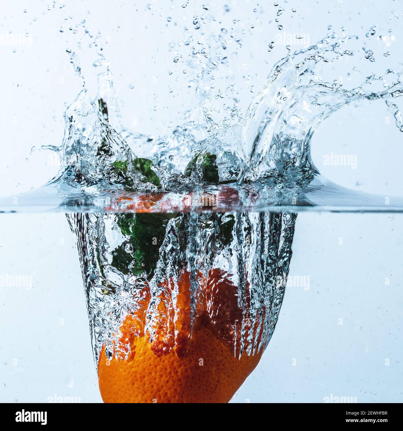 A mandarin falling into water with a splash Stock Photo - Alamy