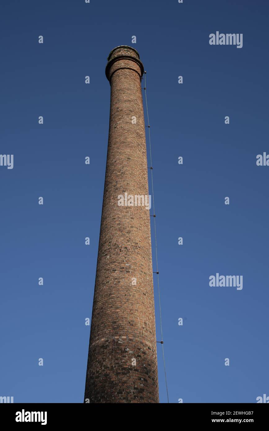 A low angle shot of an old tall chimney of ceramic factory made of ...