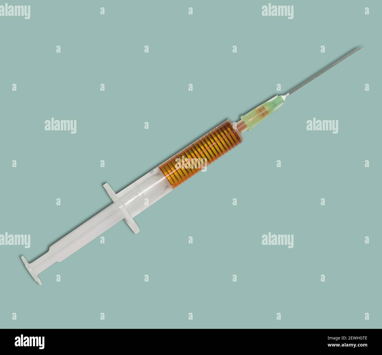 A 2ml syringe with orange medicine an a needle ready for injection ...