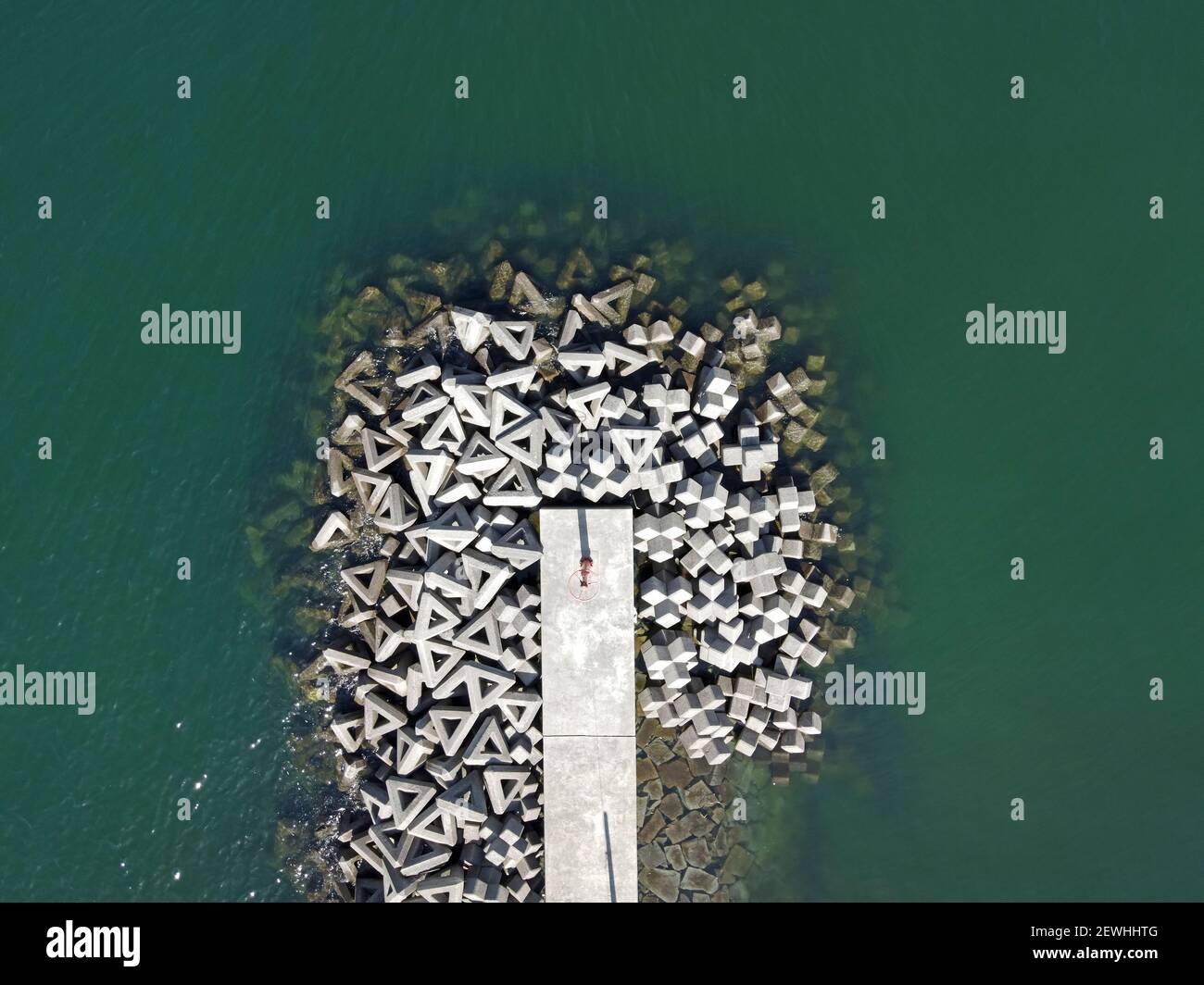 Aerial view of jetty with concrete blocks, white jetty against deep ...