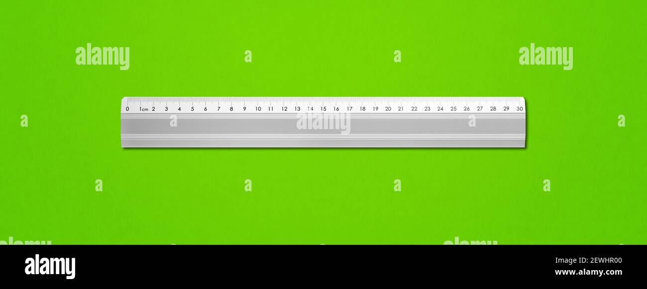 Steel metallic ruler isolated on green background Stock Photo - Alamy