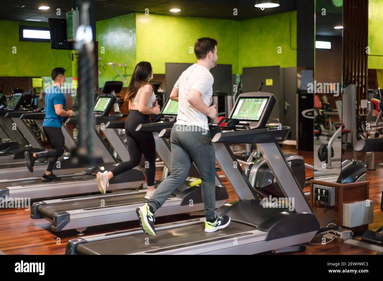 Young man running on treadmill in gym High Resolution Stock Photography ...