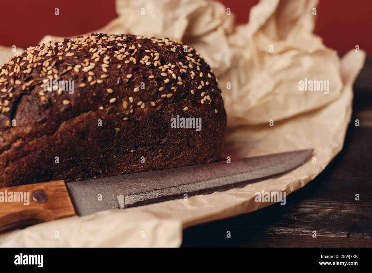 rye bread baking on paper packaging wooden table and sharp knife Stock ...