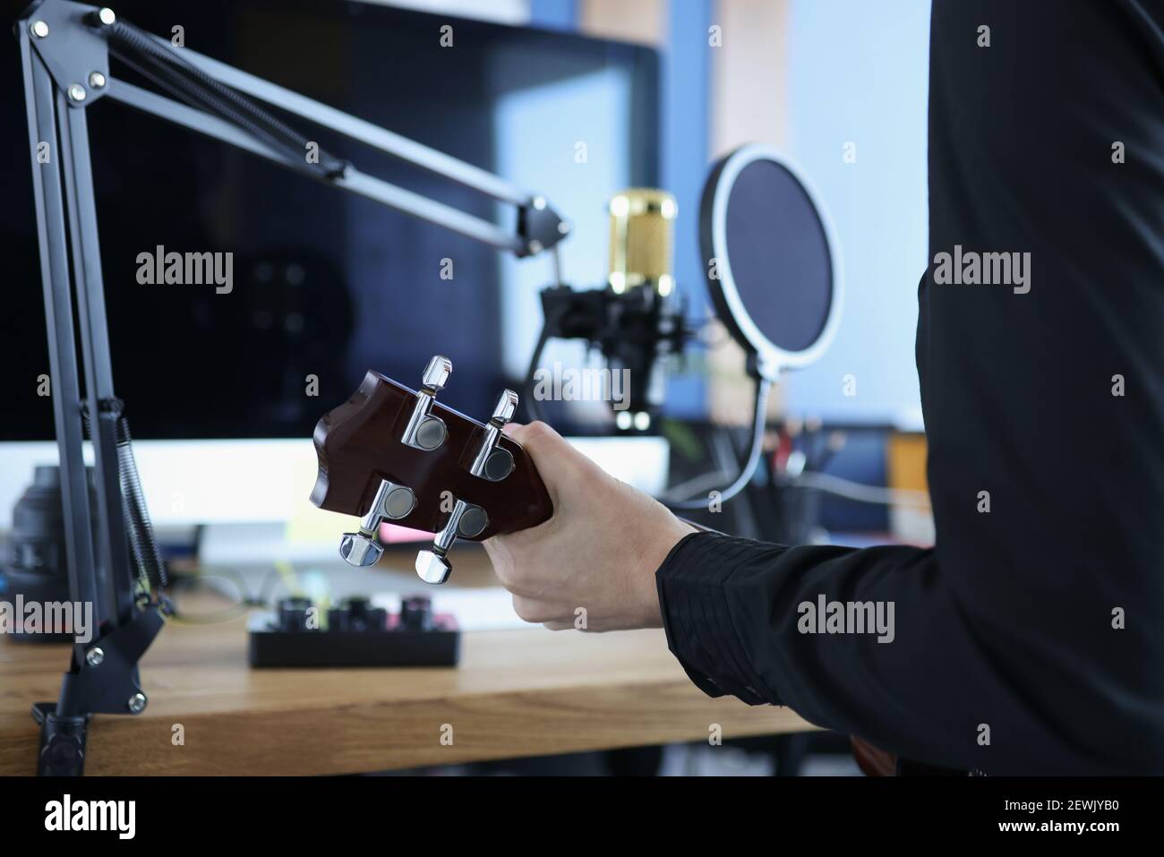 Woman hold ukulele against gold modern professional microphone Stock ...