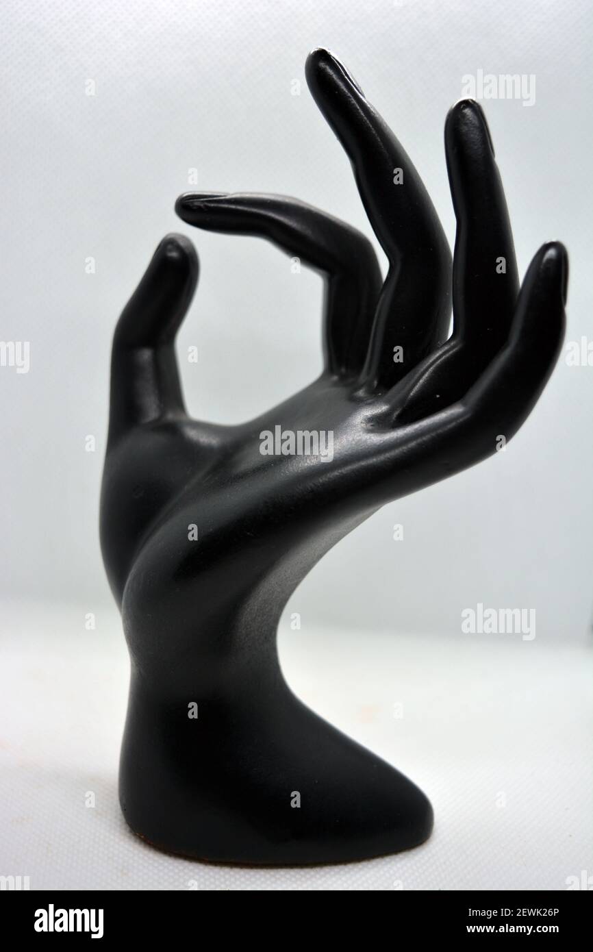 Black ceramic statue of female hand, female wrist located on a white ...