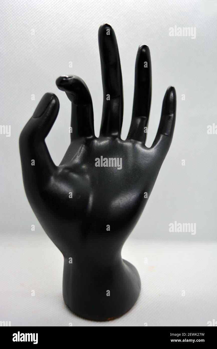 Black ceramic statue of female hand, female wrist located on a white ...