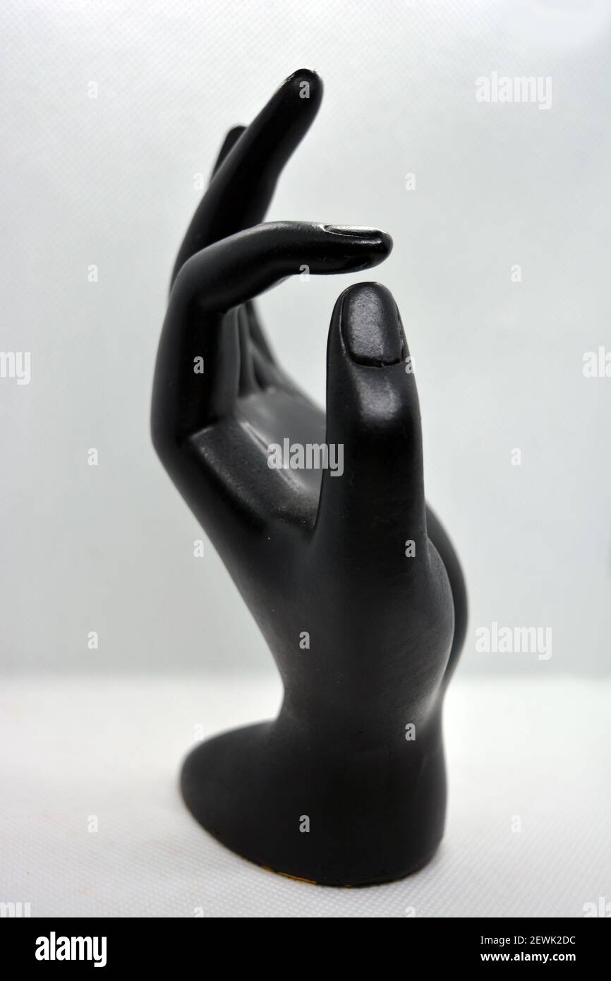 Black ceramic statue of female hand, female wrist located on a white ...