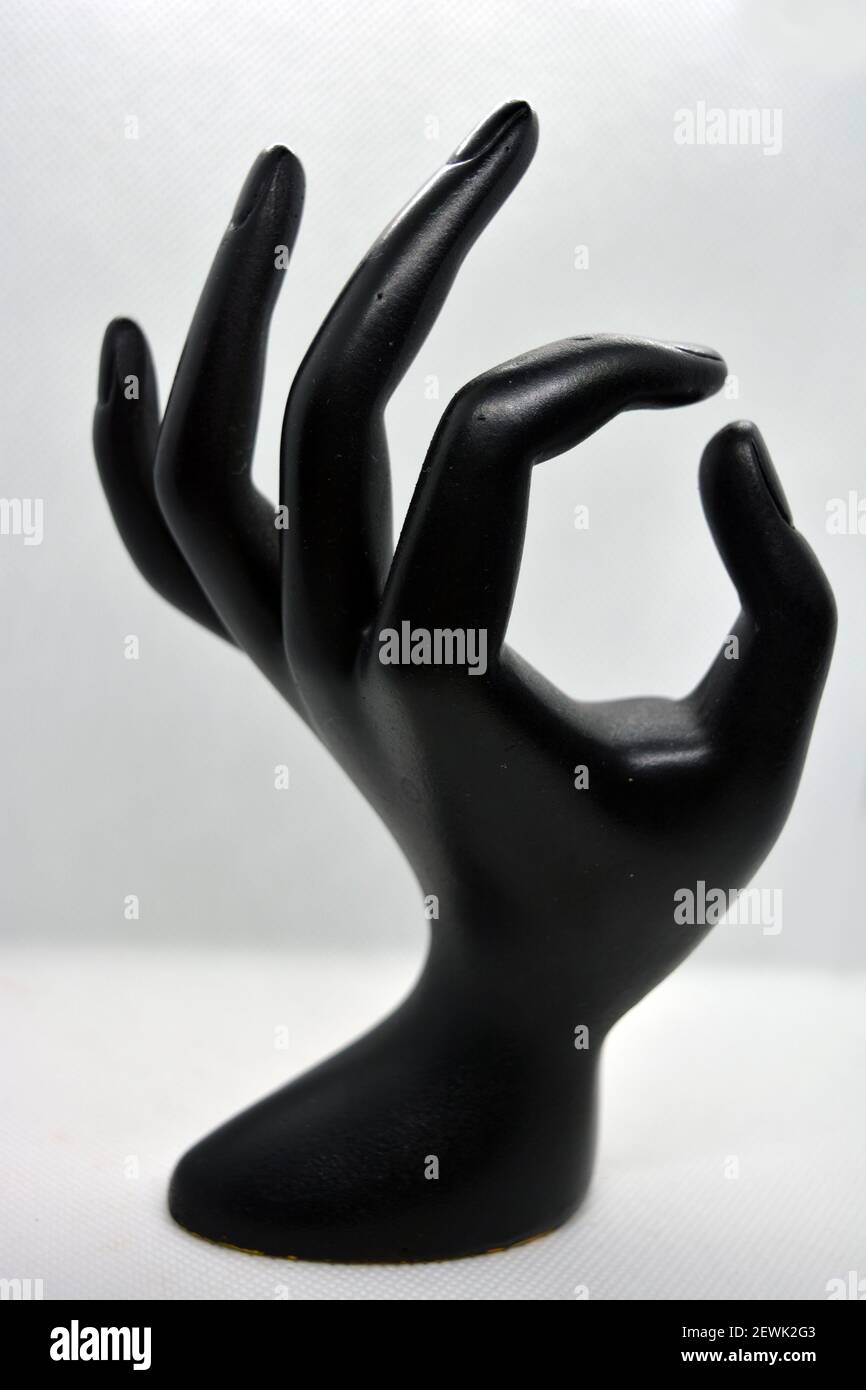 Black ceramic statue of female hand, female wrist located on a white ...