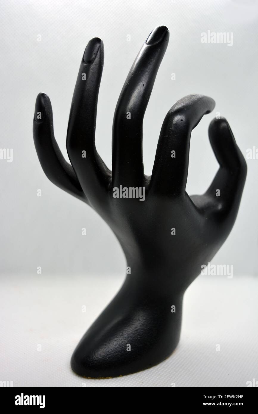 Black ceramic statue of female hand, female wrist located on a white ...