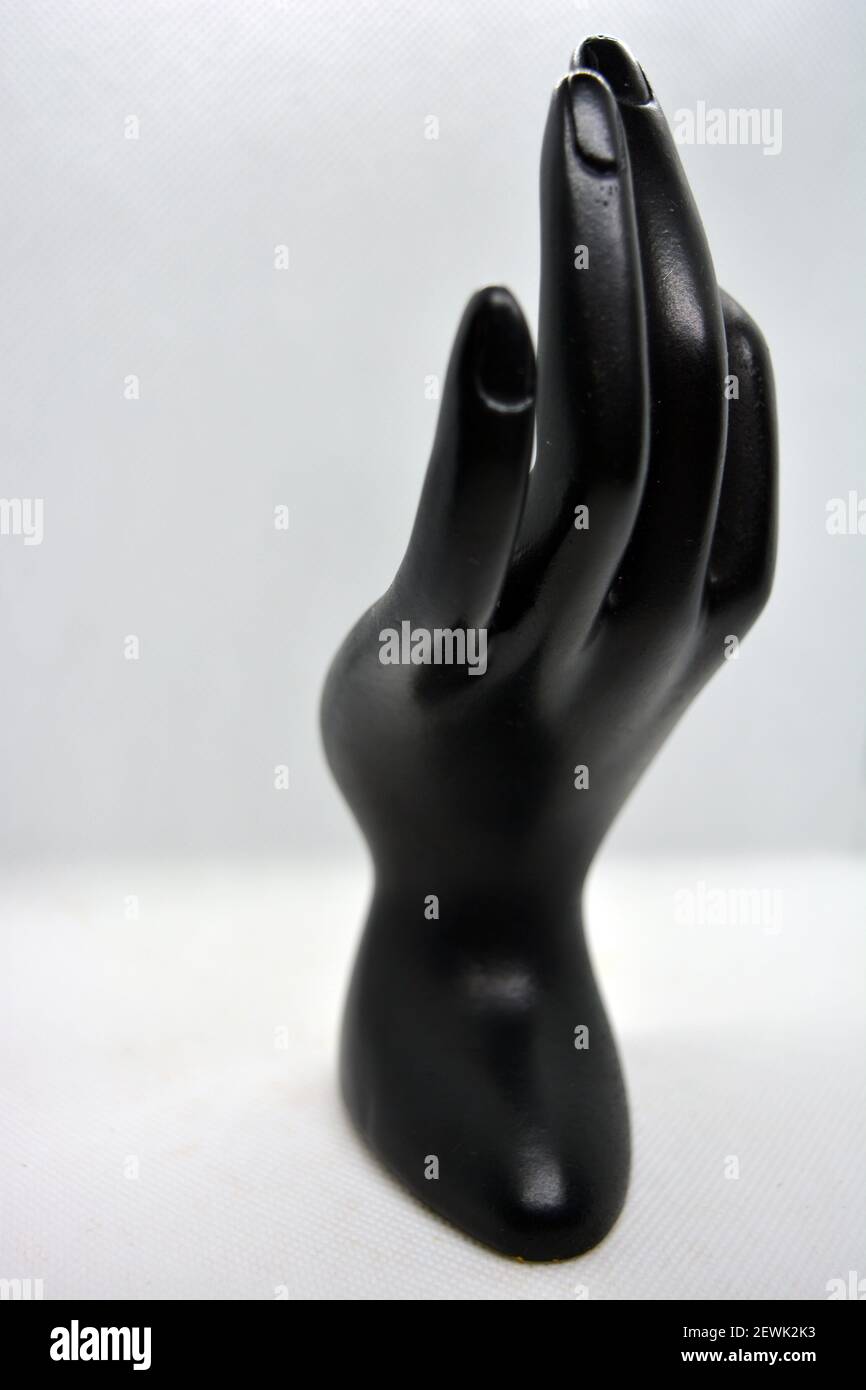 Black ceramic statue of female hand, female wrist located on a white ...