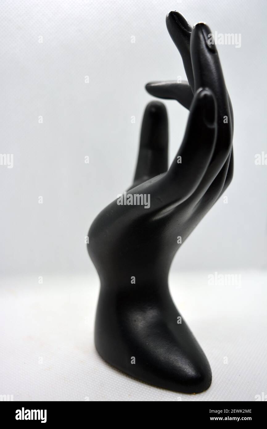 Black ceramic statue of female hand, female wrist located on a white ...