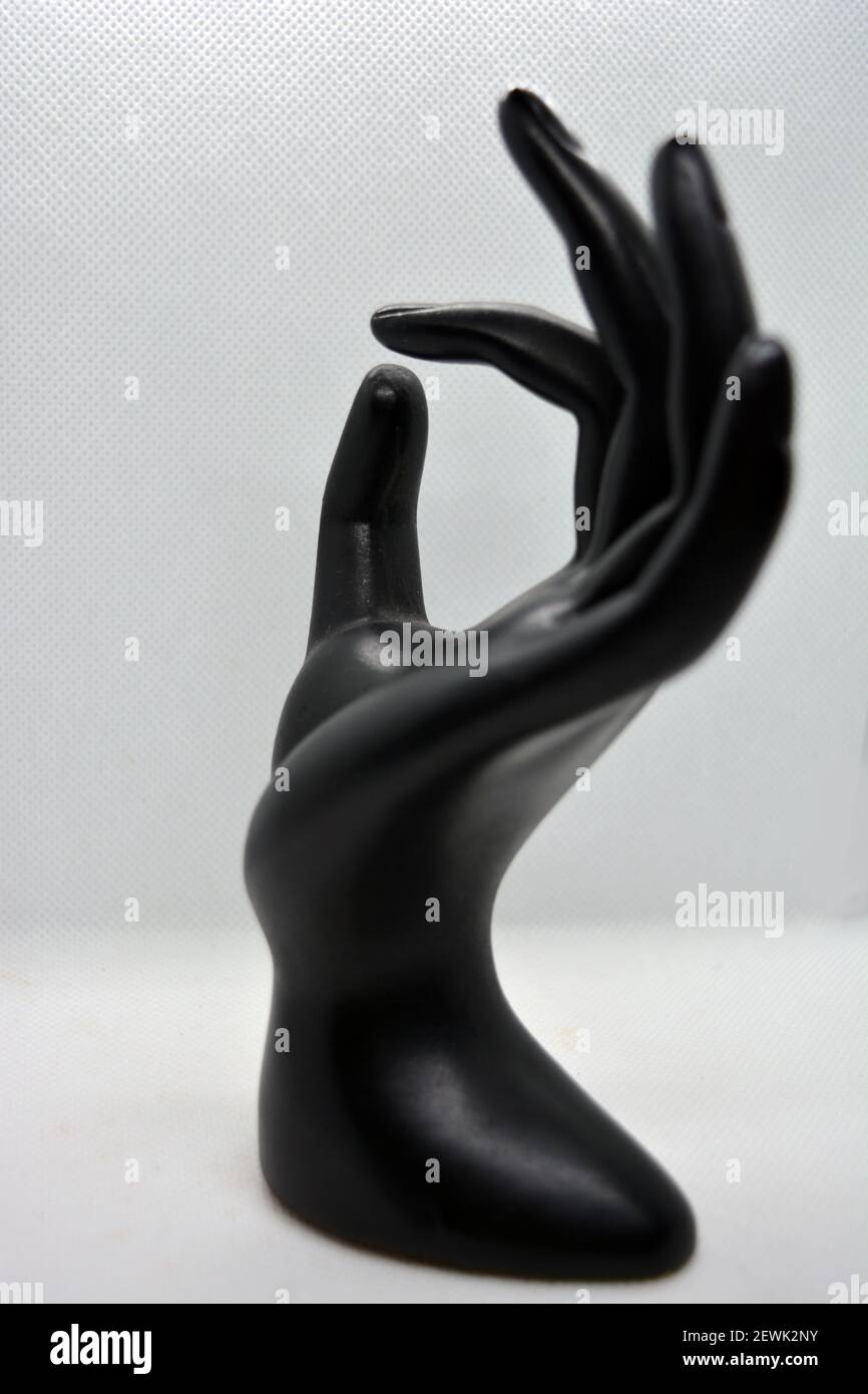 Black ceramic statue of female hand, female wrist located on a white ...