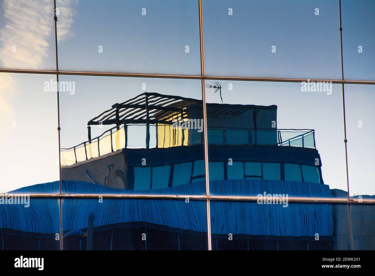 Reflections of old building rooftop in modern glass office building ...