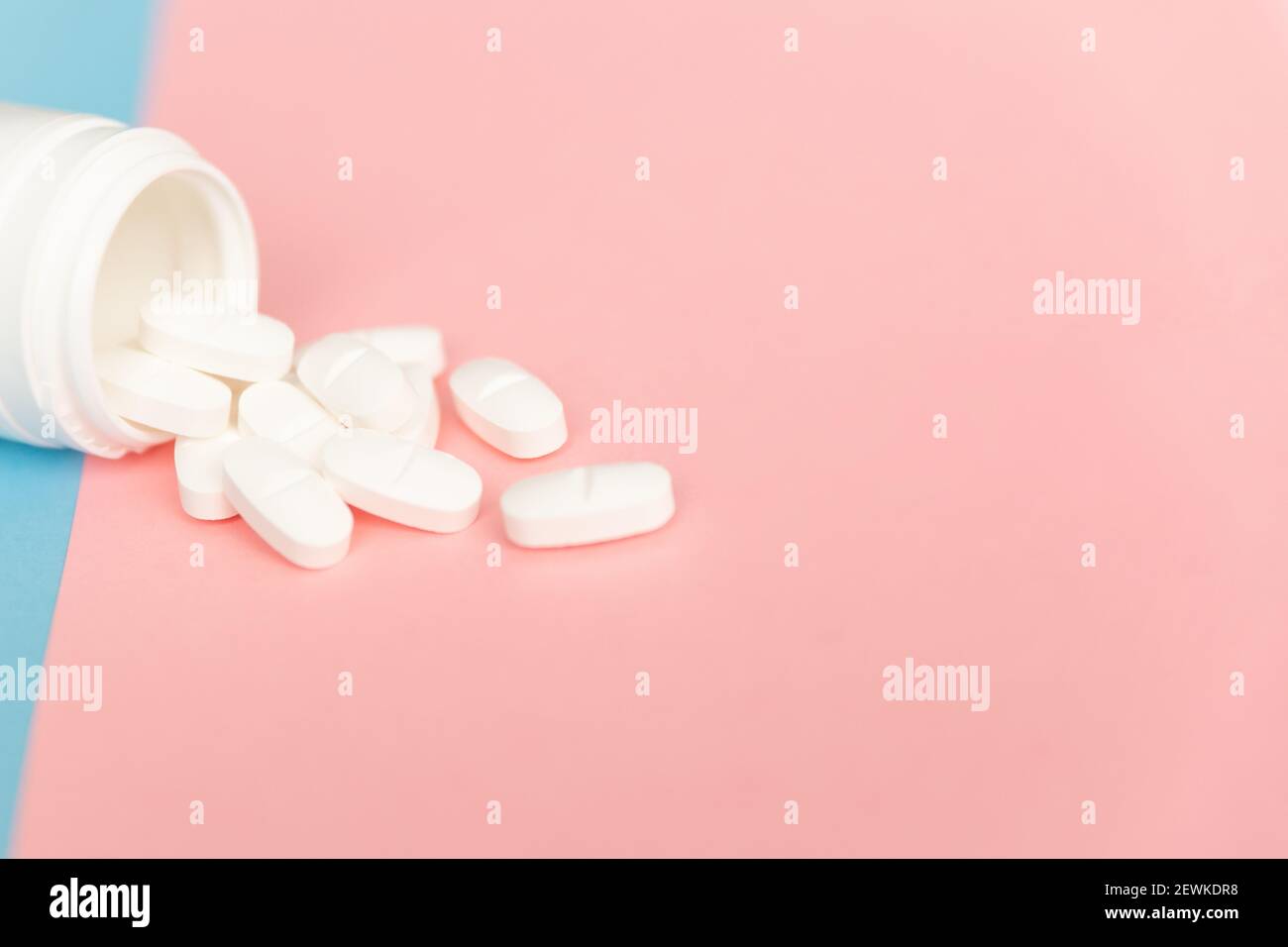 group of medicine capsules coming out of a container Stock Photo - Alamy