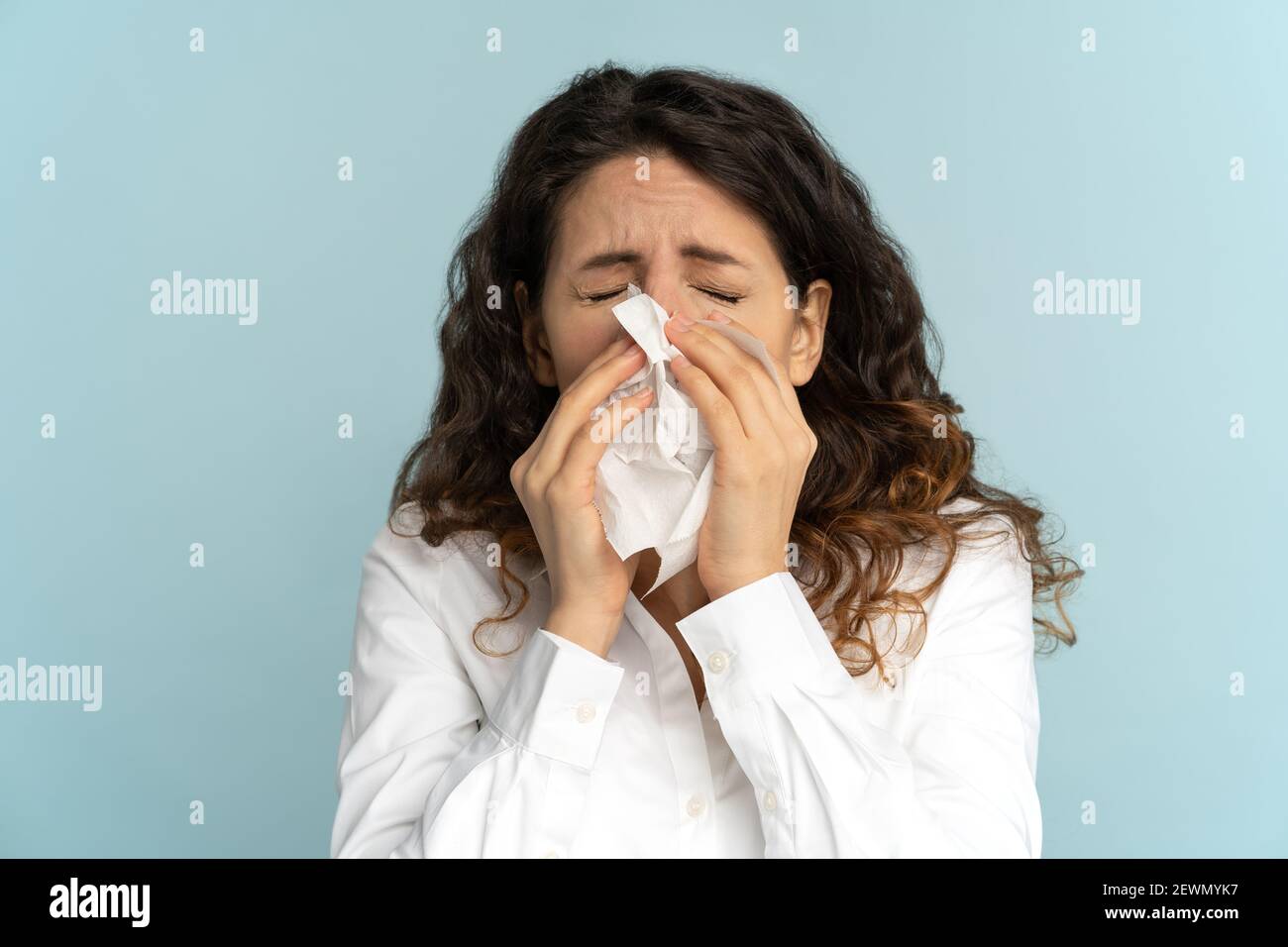 Woman sneezing into paper tissue, suffering from seasonal allergy ...