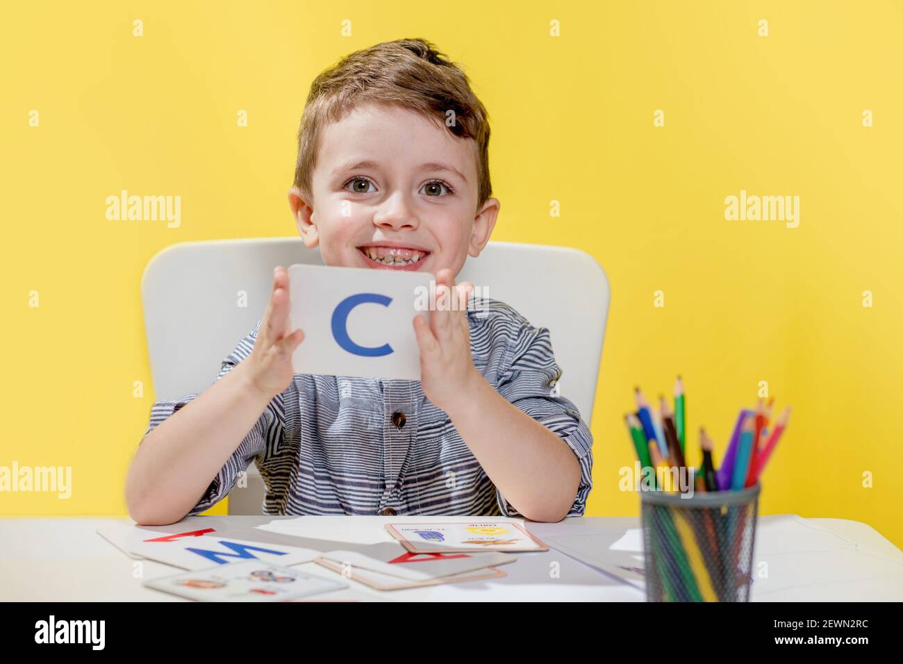 Happy smiling little preschool boy shows letters at home making ...