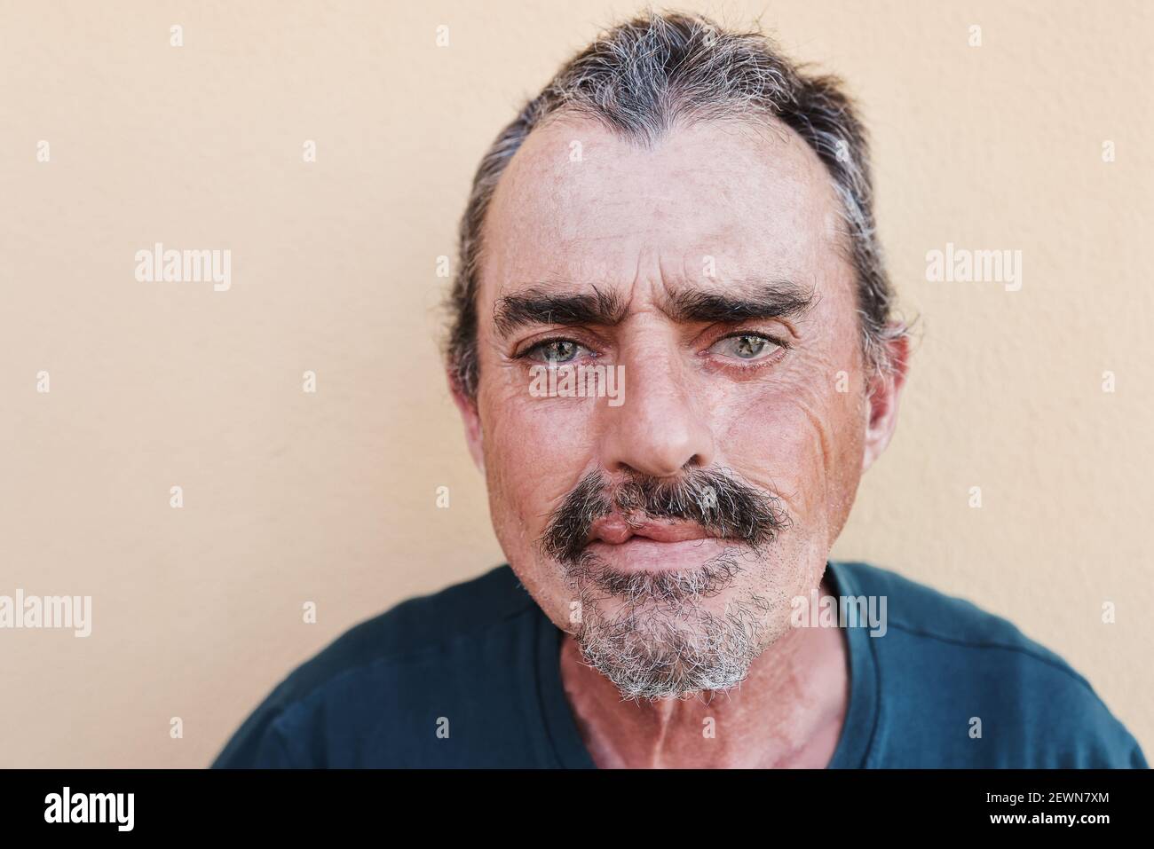 Portrait of senior man looking at camera with yellow background - Focus ...