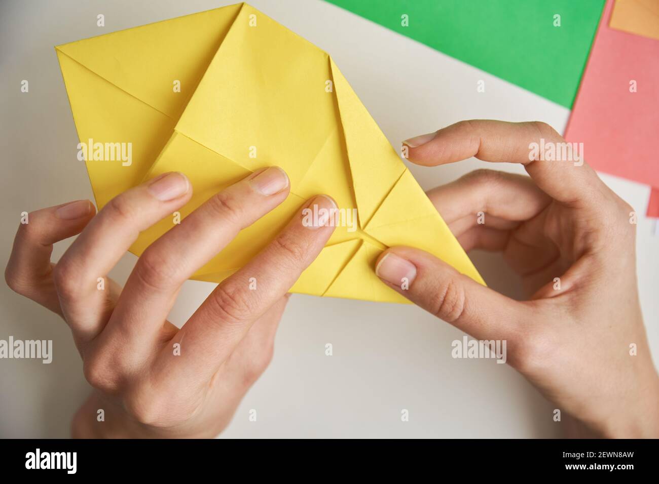 Origami lessons. Woman make origami easter rabbit from color paper. DIY ...