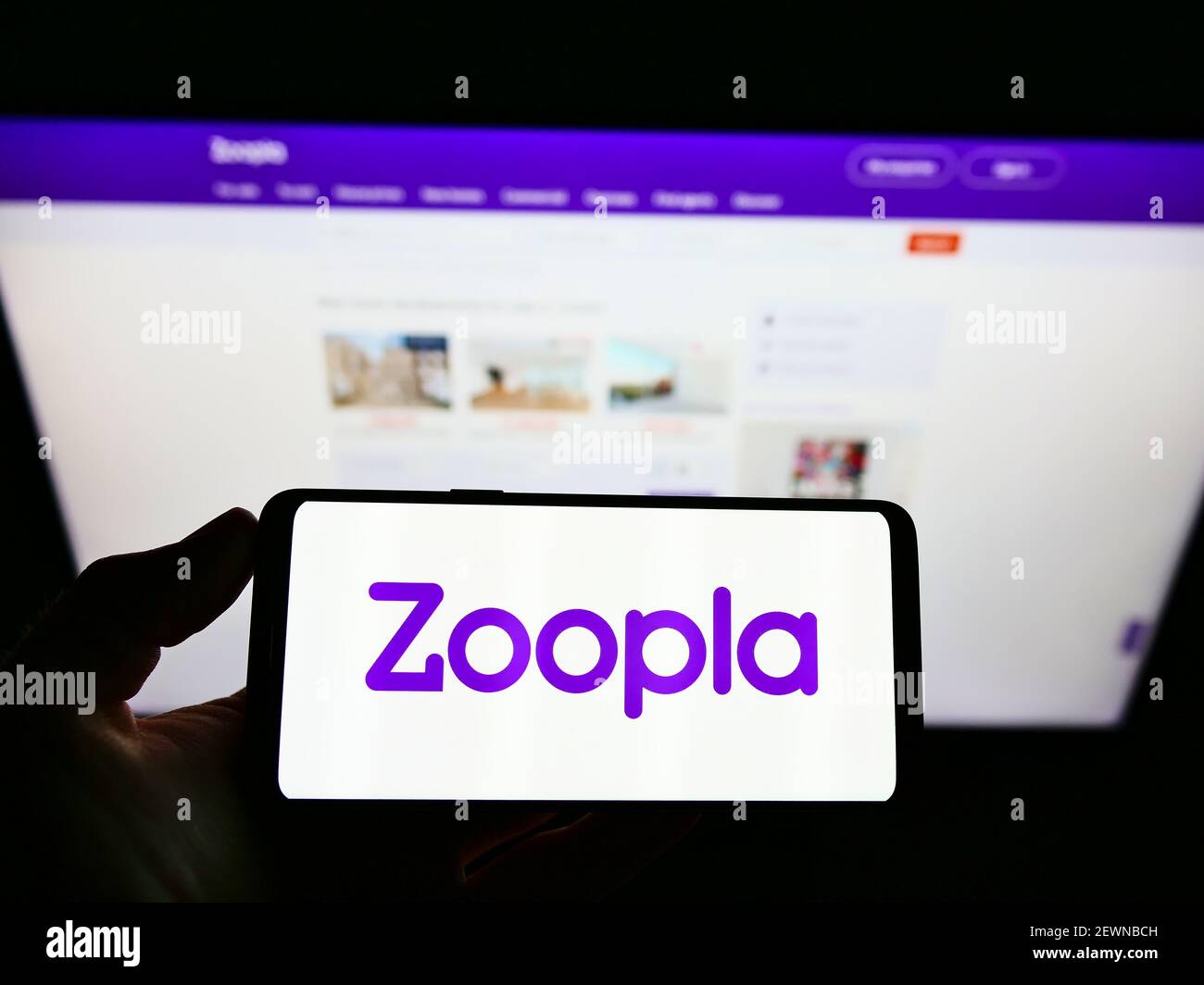 Person holding smartphone with logo of British real estate platform ...