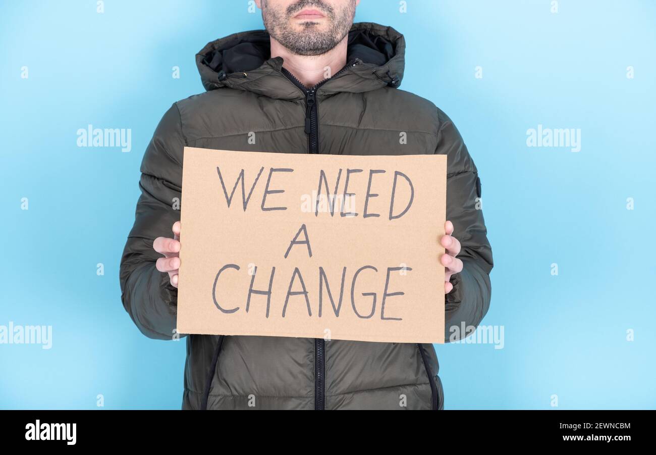 Anonymous person holding a protest sign with the words "We need a ...