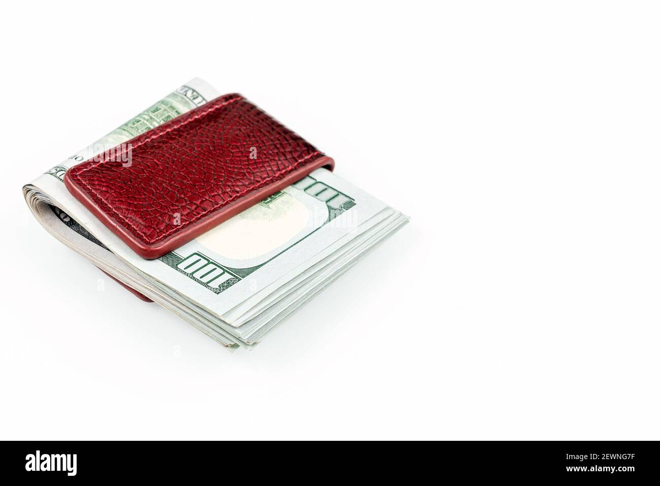 Several one hundred dollar bills folded in half. Dollars clamped by a money clip. Bundle of 100 ...
