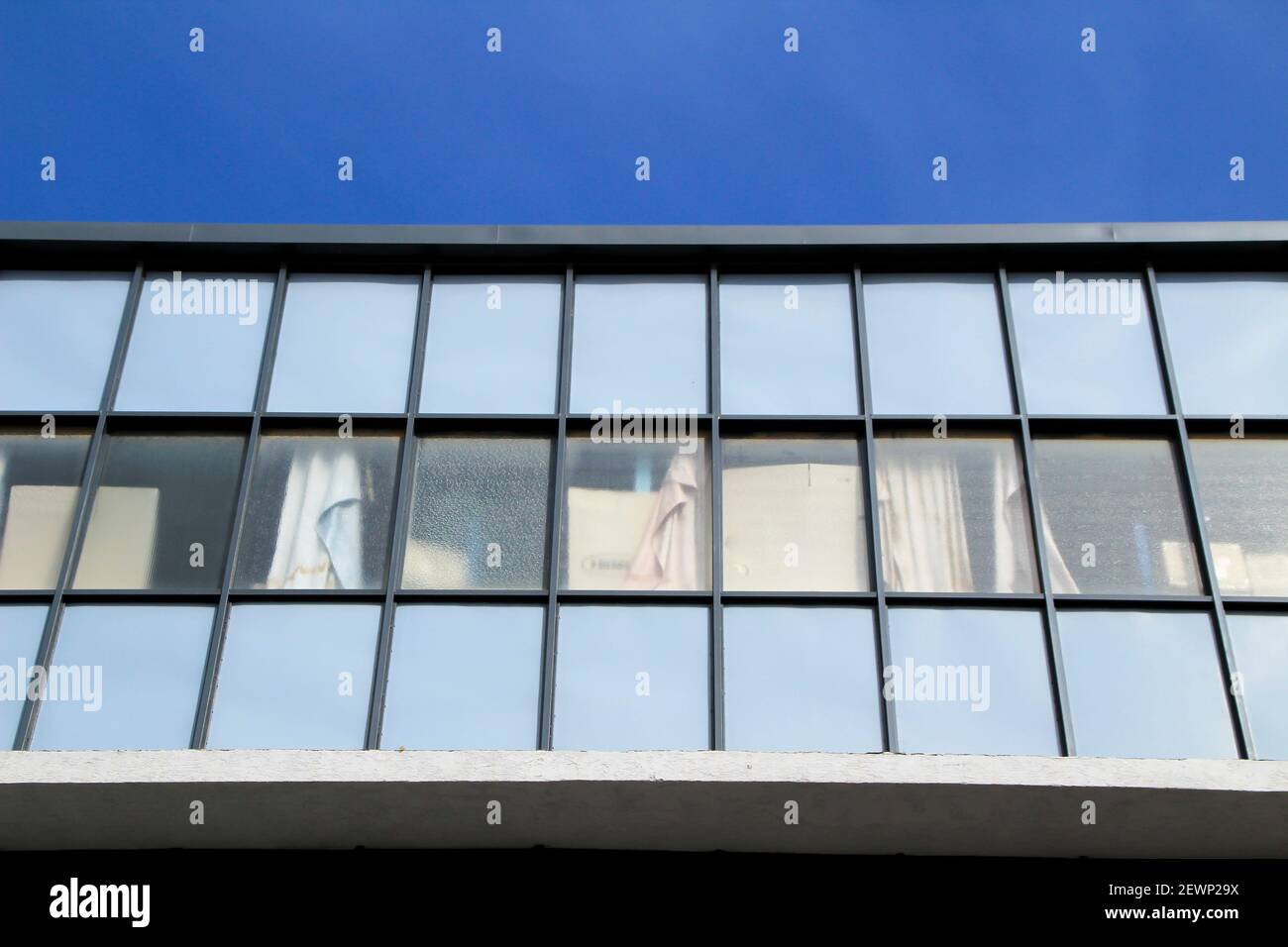 Rectilinear and geometric facade with glass windows over blue sky Stock ...