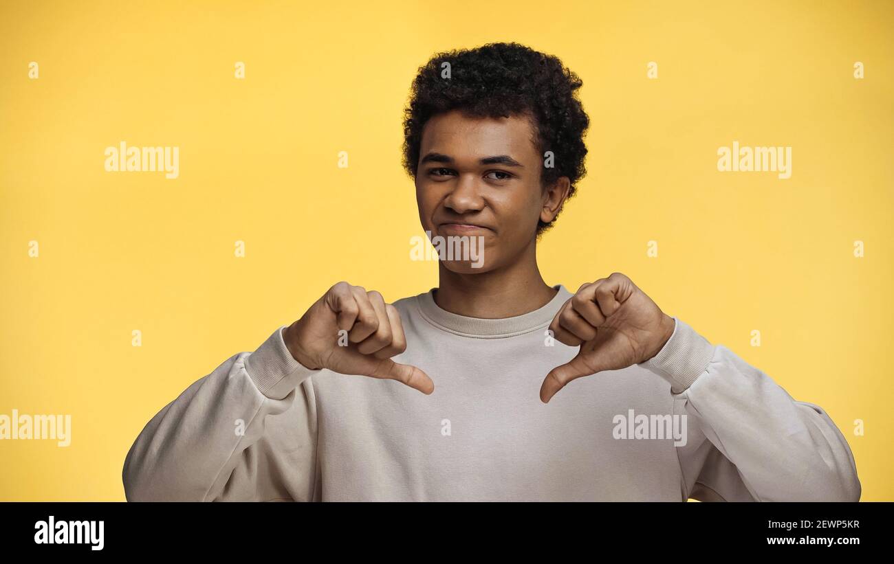 african american teenage boy showing dislike isolated on yellow Stock ...