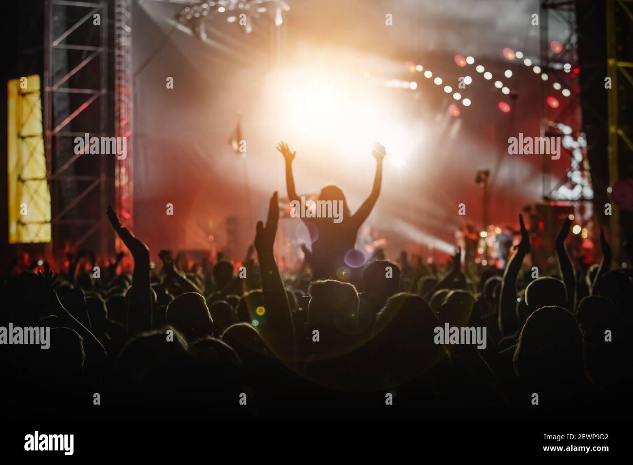 Raised hands in honor of a musical show on stage, People in the hall ...