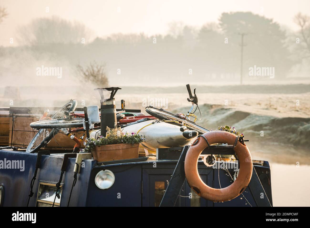 Smoke coming from chimney of wood log burning narrow canal boat on ...