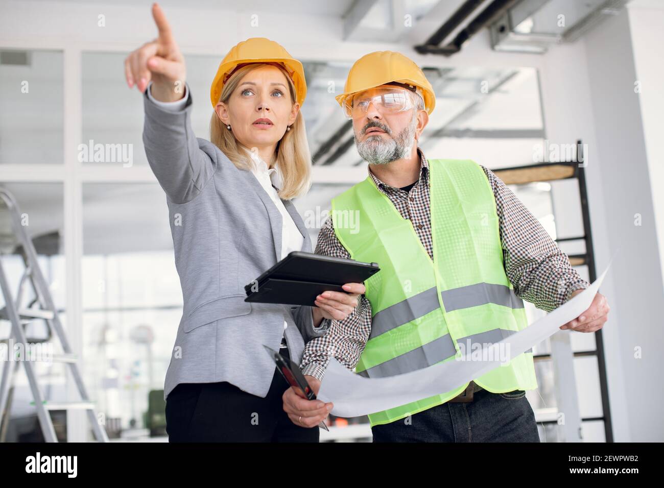 Qualified engineer and architect discussing plan of building Stock ...