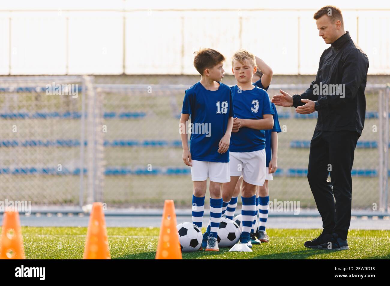 Soccer Coach Motivating Kids on Training. Young Coach With Kids in ...