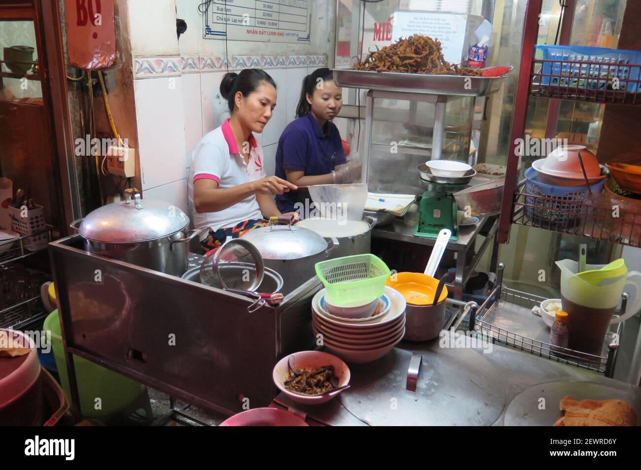 A woman uses a bamboo stick to make steamed rice pancakes. (Photo by ...
